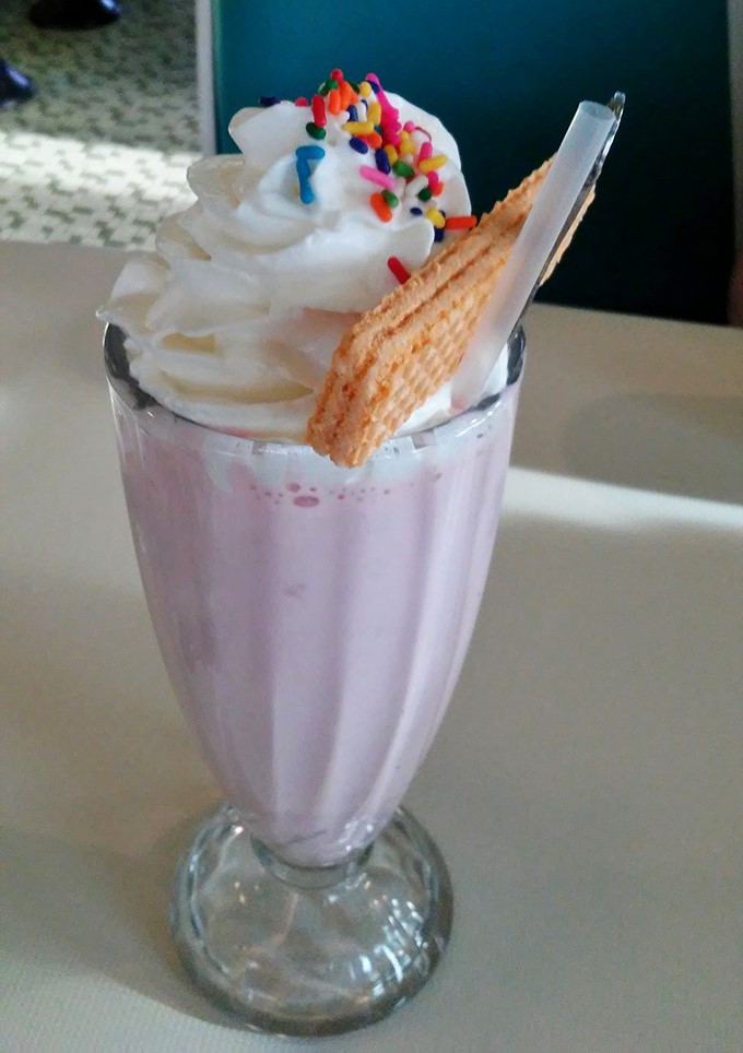 This isn't just a milkshake; it's dessert architecture. The wafer cookie stands like a sail on a pink sea of childhood memories and adult indulgence.