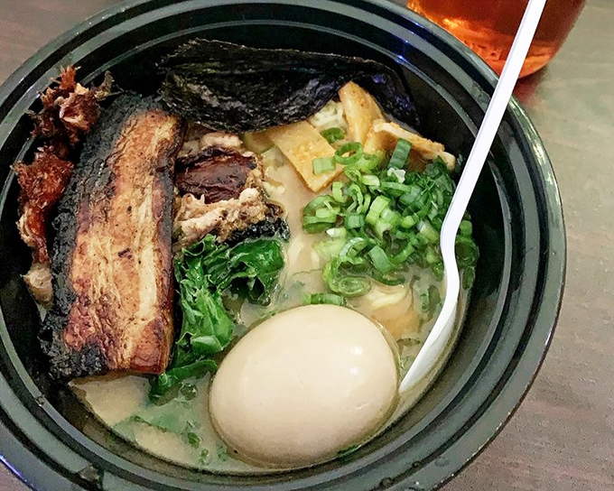 A perfectly poached egg floating in golden broth like the sun rising over a sea of noodles—this is breakfast, lunch, and dinner in one glorious bowl.