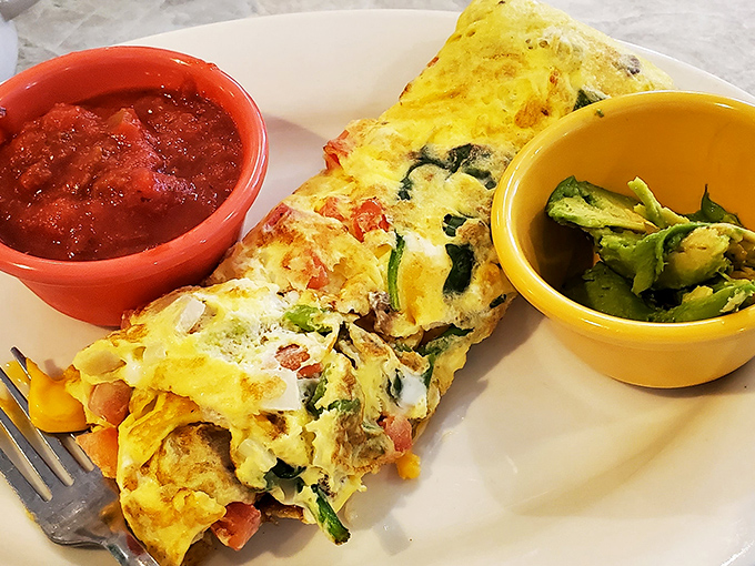 This isn't just an omelet; it's a vegetable party wrapped in an egg blanket, with salsa and avocado bringing their A-game to breakfast.