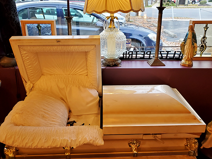 "Please don't touch—over 100 years old!" warns the sign beside this macabre coffin display that brings Victorian funeral practices into modern view.