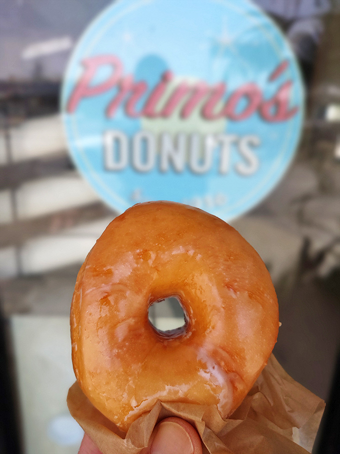 The classic glazed donut—so simple yet so profound—hovering before the Primo's logo like the food equivalent of a Renaissance painting.