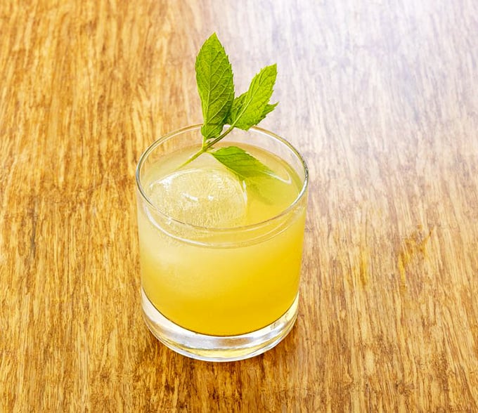 Sunshine in a glass! This bright Peach Sour cocktail, garnished with fresh mint, offers the perfect balance of sweet and tangy&mdash;like summer decided to stick around for dinner.