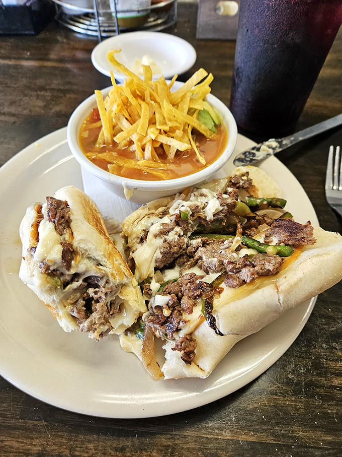 The Philly cheesesteak that launched a thousand napkins, accompanied by tortilla strips standing at attention above homemade soup.