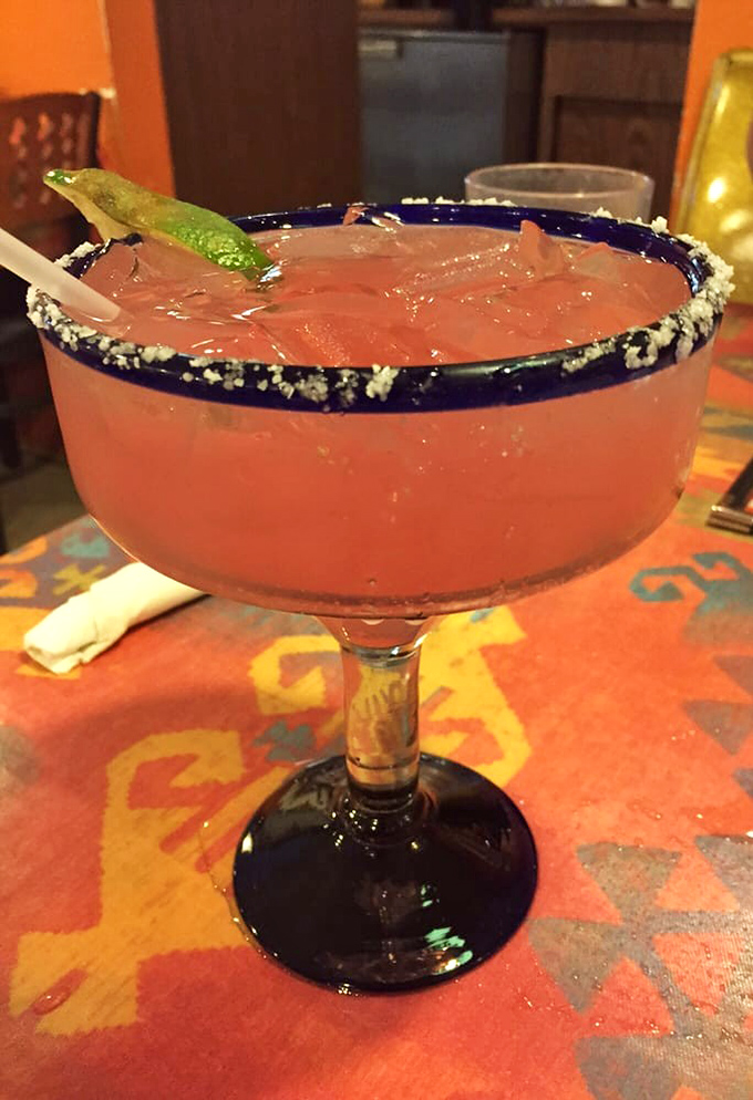 The Prickly Pear Margarita delivers Southwest sunshine in liquid form, rimmed with salt and topped with a lime wedge.