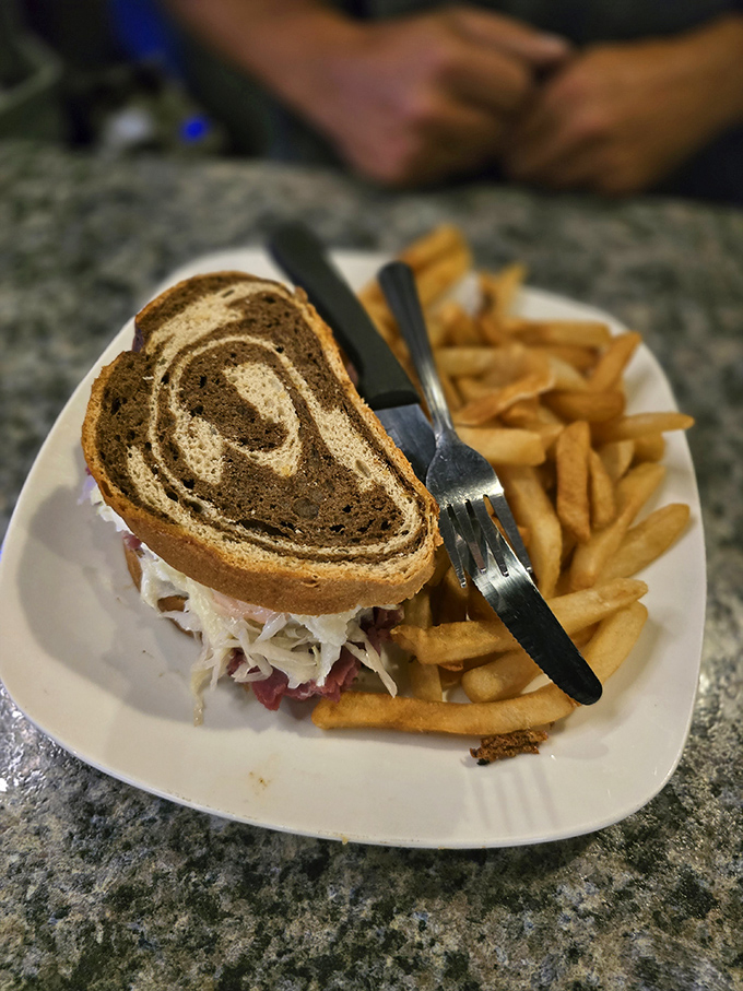 Marble rye holding together the perfect ratio of corned beef, sauerkraut, and Swiss—this Reuben isn't just a sandwich, it's a commitment.