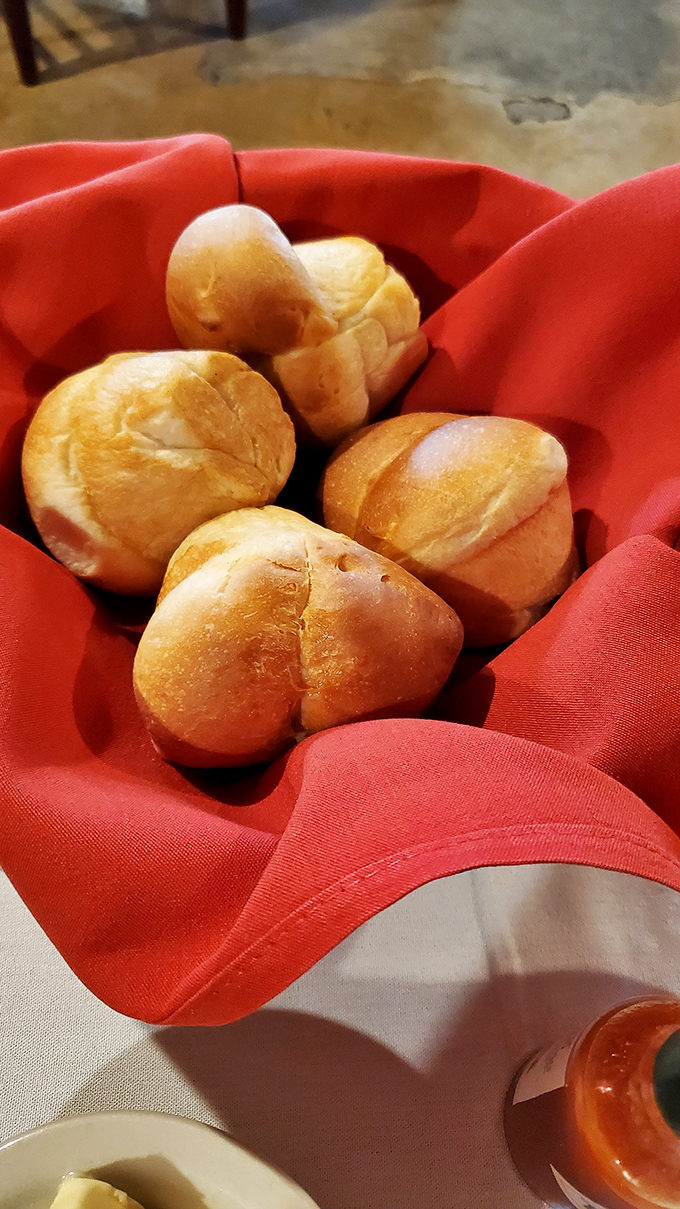 These warm dinner rolls arrive in their red napkin nest like edible comfort wrapped in carbs and butter dreams.