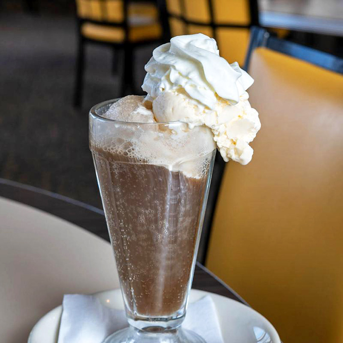 The chocolate shake arrives with whipped cream standing tall like a dairy Everest, daring you not to immediately regress to childhood glee.