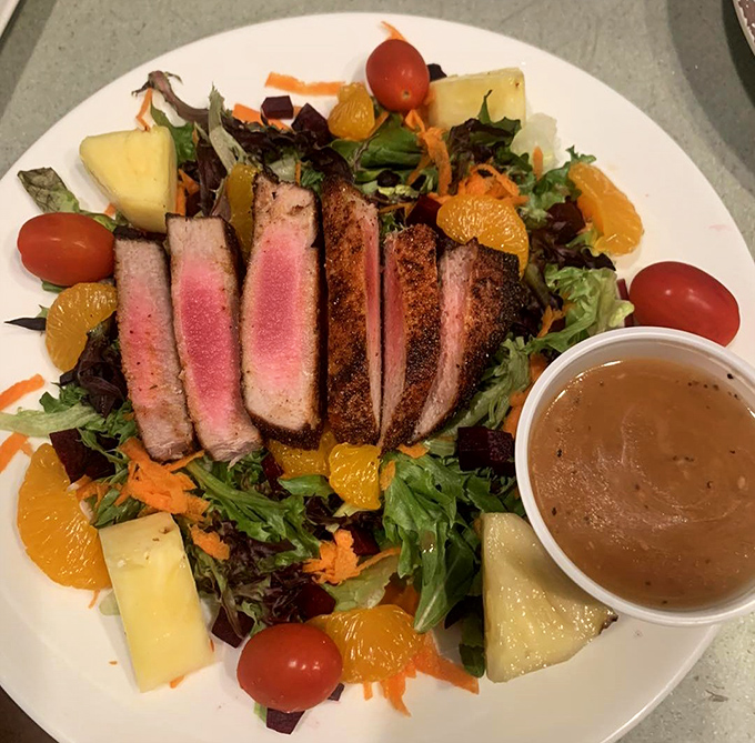 Fresh salad greens topped with perfectly seared steak create lunch elegance in this cozy breakfast haven.