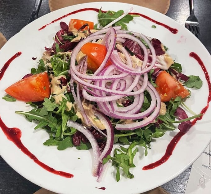 Even the salads show up dressed to impress, with vibrant rings of red onion playing nicely with fresh greens and juicy tomatoes.