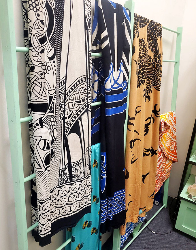 Vintage scarves hanging like colorful flags of fashion history. Each pattern tells a story of the decade that embraced it.