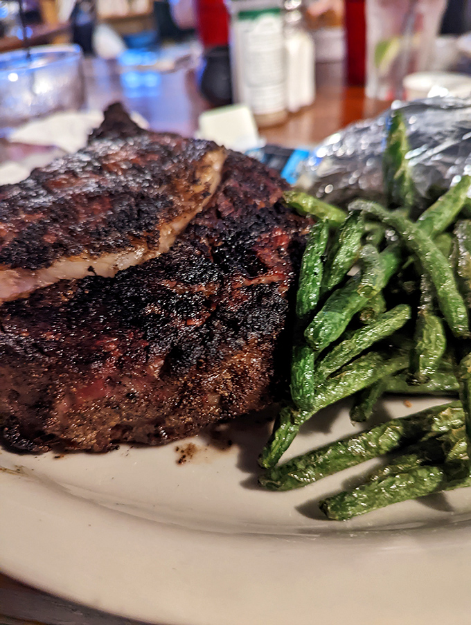 A perfectly seared steak alongside bright green beans &ndash; simple food done right is the ultimate form of culinary respect.