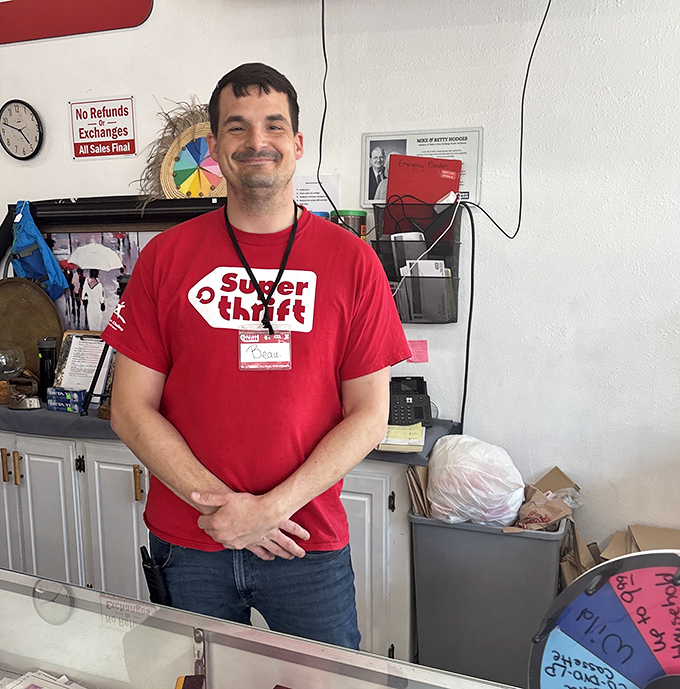 The friendly face of thrift shopping wears a SuperThrift red shirt and the satisfied smile of someone who knows where all the best deals hide.