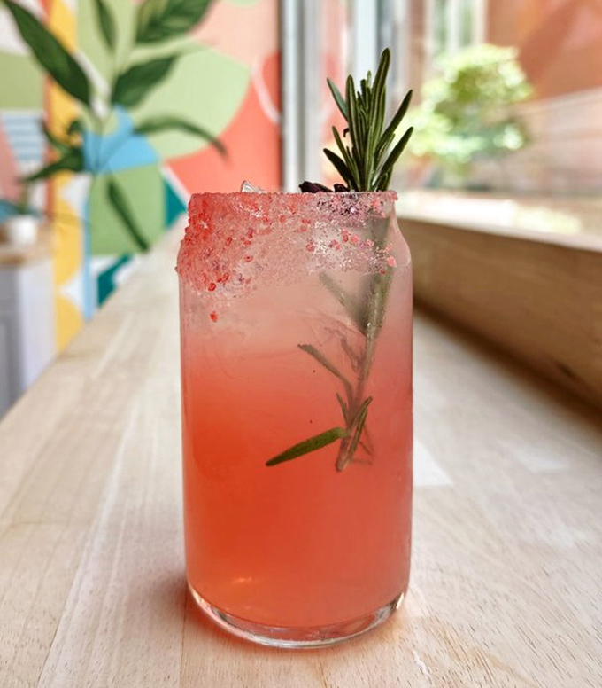 This isn't just a pink drink; it's summer in a glass with a rosemary sprig playing lifeguard. Refreshment has never looked so photogenic.