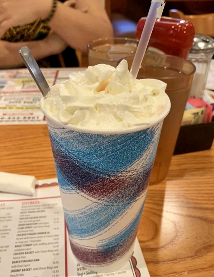 A milkshake dressed in its Sunday best. That whipped cream crown isn't just decoration&mdash;it's a dairy kingdom's royal headwear.