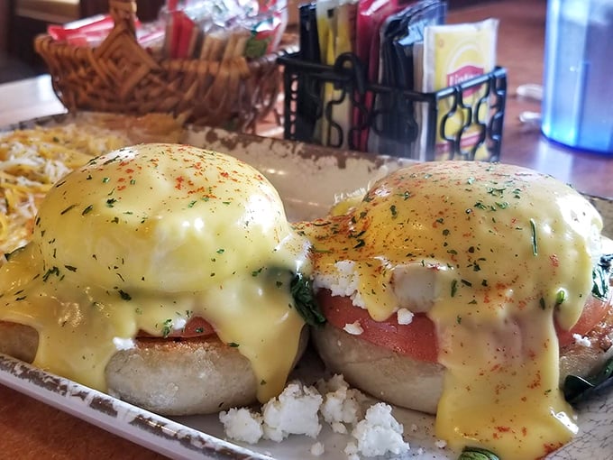 Eggs Benedict reimagined: perfectly poached eggs perched atop English muffins, draped in hollandaise that flows like liquid sunshine.