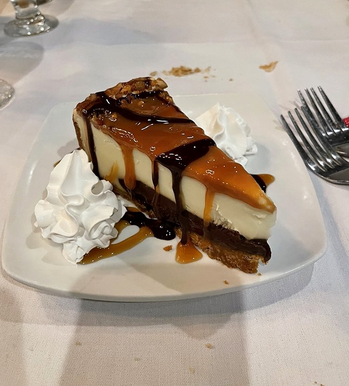 Caramel and chocolate drizzle transform cheesecake from dessert to artwork. The whipped cream is just the frame for this masterpiece.