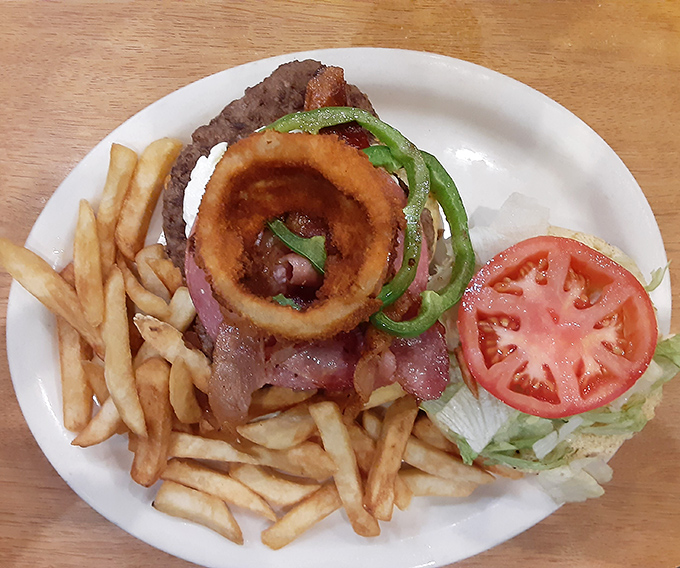 The Uncle John Bacon Burger comes dressed for success with crispy onion rings playing king of the mountain.