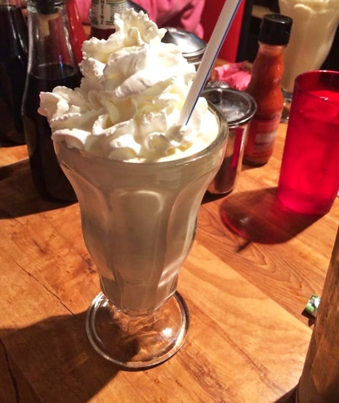 A milkshake so thick and creamy it's practically standing at attention, topped with enough whipped cream to make a dairy cow blush.