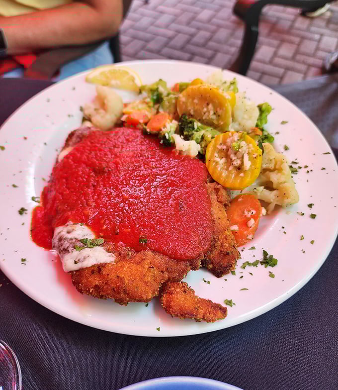 Veal Parmigiana served with colorful vegetables that brighten the plate like confetti at an Italian wedding &ndash; a celebration on a dish.