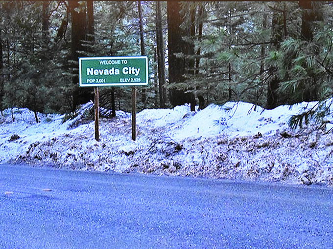 The "Welcome to Nevada City" sign greets winter visitors, promising small-town warmth even when surrounded by a wonderland of Sierra snow.