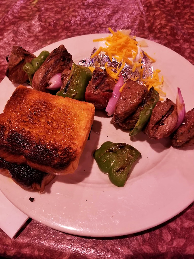 Meat and vegetables finding harmony on a skewer, like a delicious kebab chorus line performing next to a perfectly grilled Texas toast soloist.