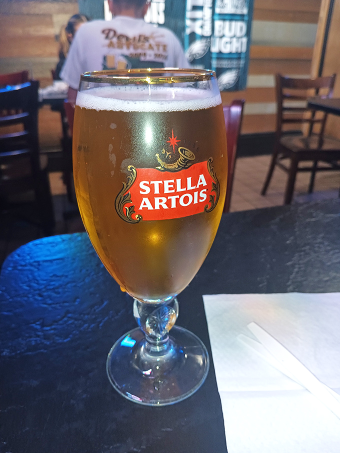 A golden chalice of Stella Artois stands ready to wash down your sandwich&mdash;because even royalty needs something to drink.