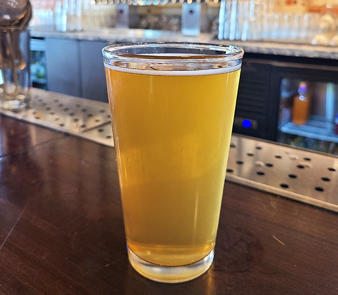 A perfectly poured craft beer catching the light like liquid gold &ndash; silent proof that Oklahoma's brewing scene deserves your attention.
