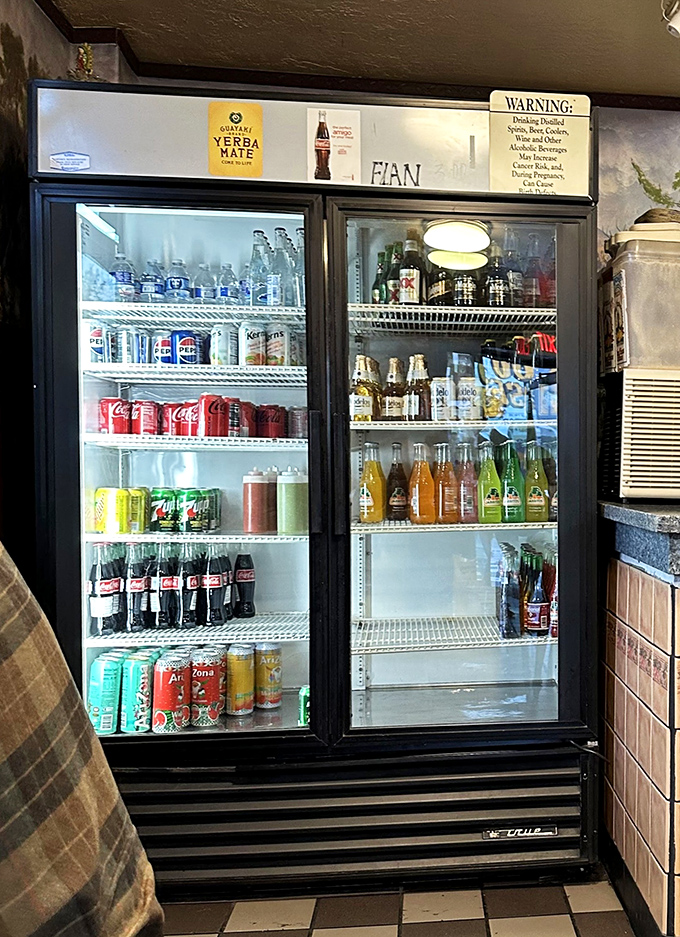The beverage cooler – a colorful oasis of Mexican sodas and American classics, where the Jarritos and Coke bottles stand shoulder to shoulder in fizzy harmony.