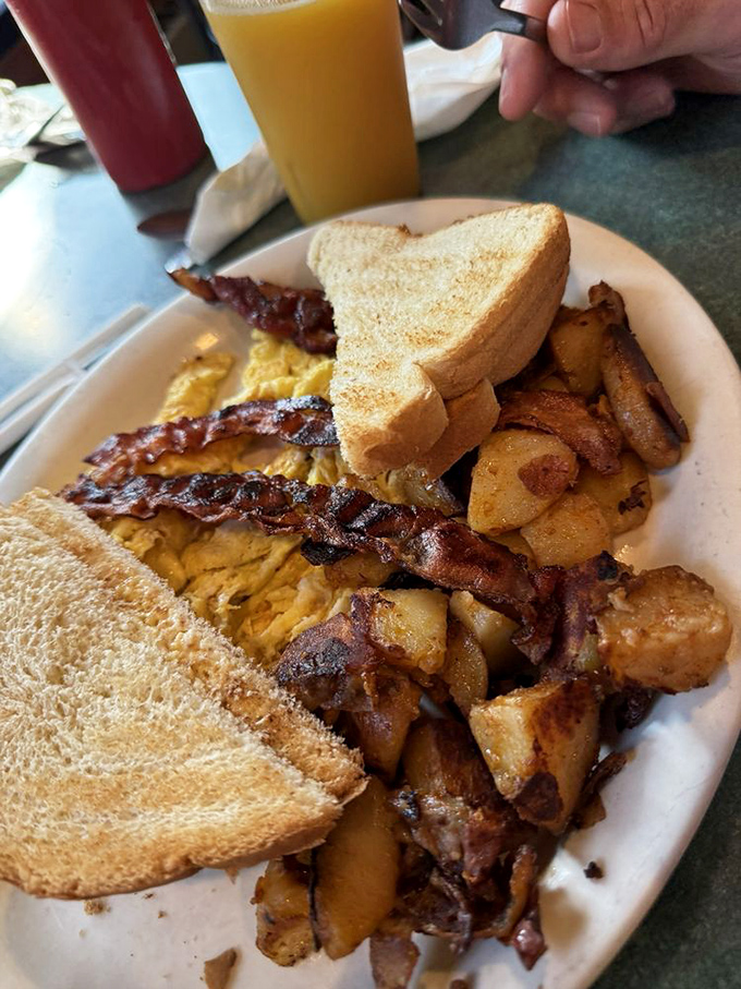 The breakfast platter that answers the eternal question: "Why choose between bacon, eggs, and home fries when you can have the whole magnificent trio?"