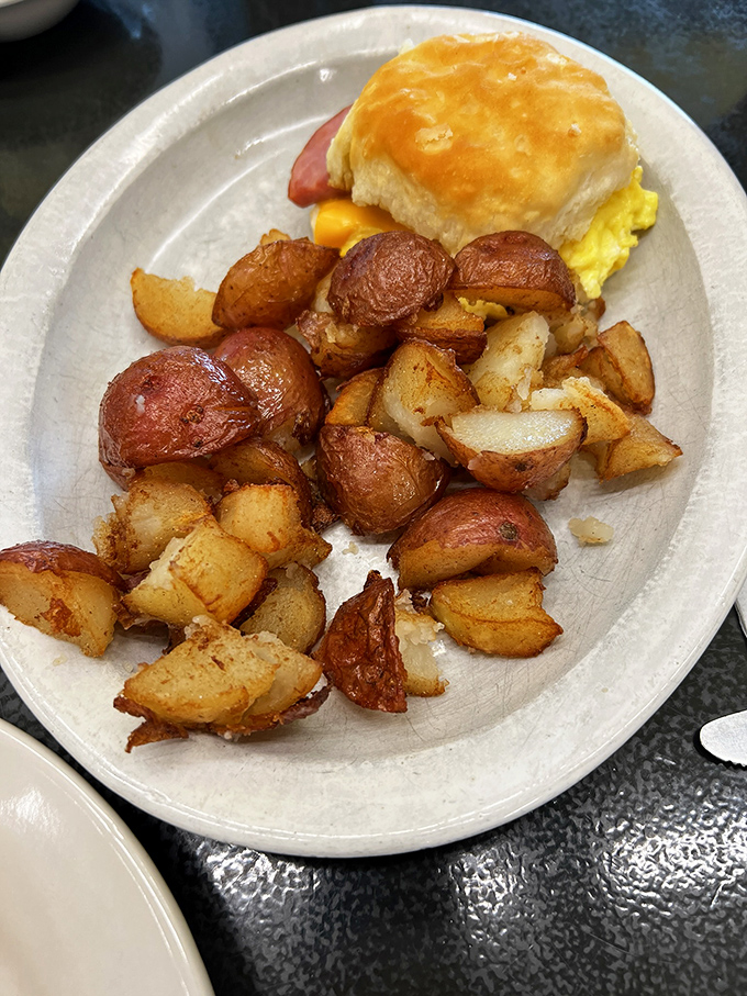 A breakfast sandwich that means business, paired with home fries that have achieved that mythical balance of crispy exterior and fluffy interior.