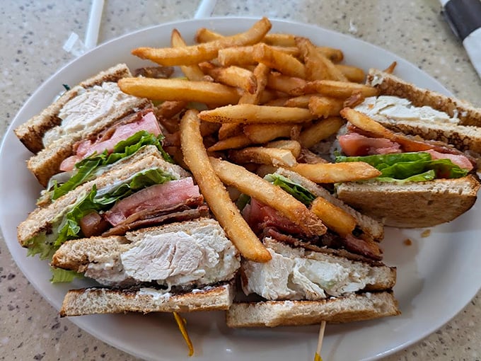 The club sandwich: three layers of pure satisfaction surrounded by a golden fortress of perfectly cooked fries. A timeless classic.