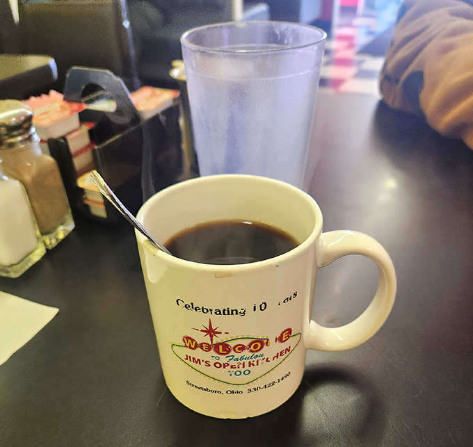 The coffee mug says "Celebrating 10 Years," but the coffee inside says "Good morning" in a language everyone understands.
