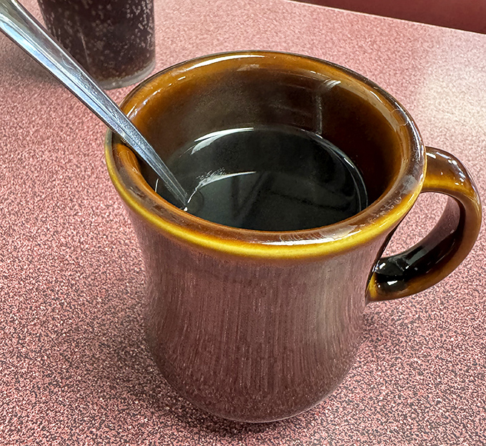 That brown ceramic mug isn't just holding coffee&mdash;it's cradling liquid motivation in the unpretentious vessel every proper diner deserves.
