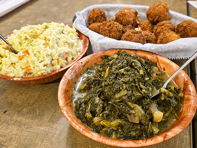 Coleslaw and turnip greens in wooden bowls alongside golden hushpuppies&mdash;side dishes that refuse to be upstaged by the main event.