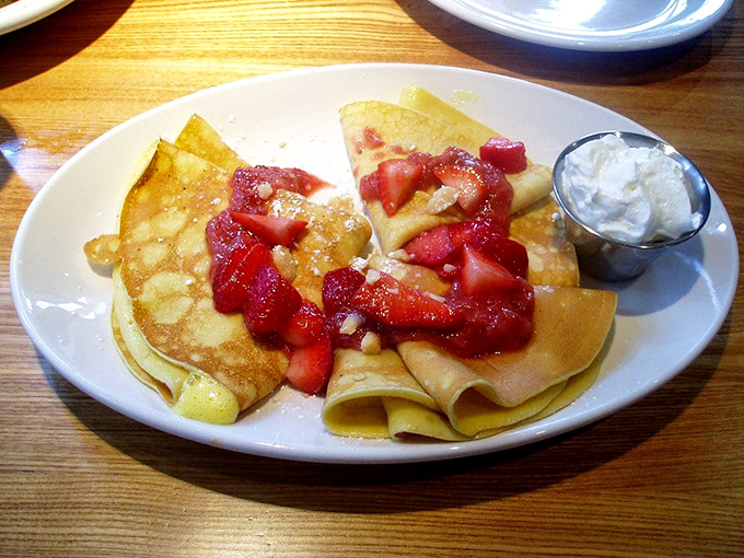 Thin, delicate crepes embracing fresh strawberries like old friends reuniting. A breakfast romance that ends happily ever after in your stomach.