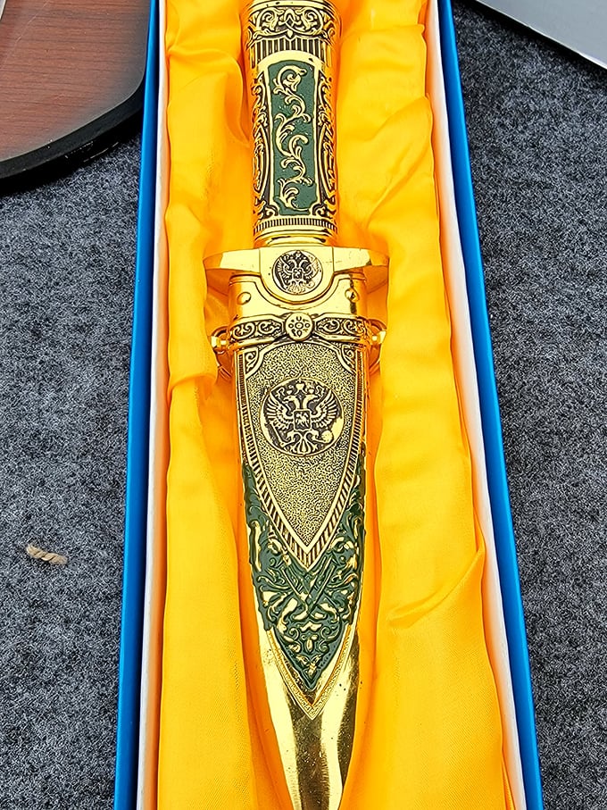 An ornate ceremonial dagger gleams in its presentation box, the kind of unexpected find that makes flea markets magical.