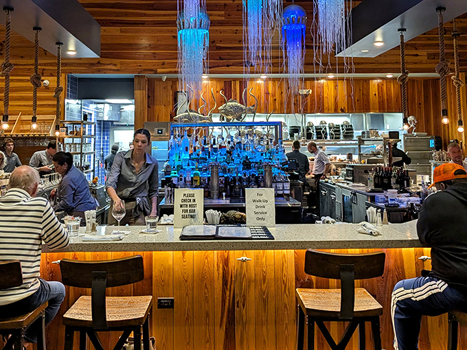 The bar scene at Hook & Barrel is where coastal cool meets craftsmanship, with jellyfish lights that make you feel like you're dining under the sea.