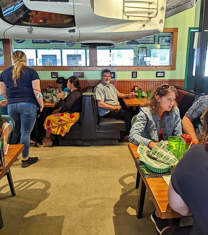 The booths at Quaker Steak & Lube aren't just seating—they're front-row tickets to the automotive museum that happens to serve incredible food.
