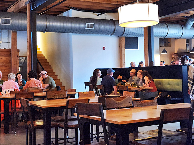The dining room buzzes with conversation as patrons gather around wooden tables, united by good food and the promise of craft beer.