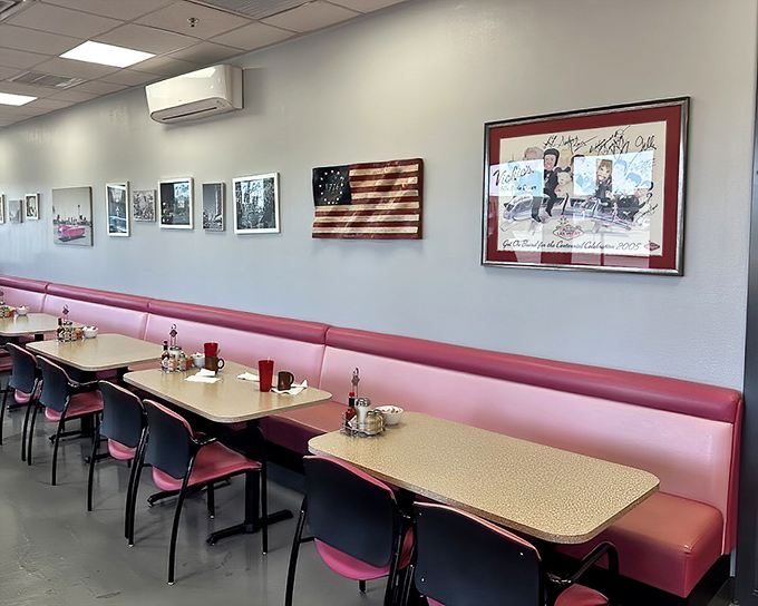 The dining area wall showcases Vegas memorabilia that tells stories the Strip would rather forget. These pink booths have heard it all.