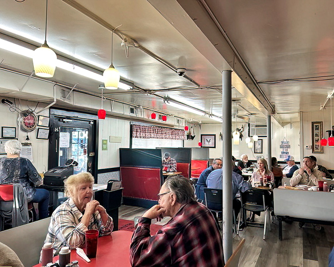 The dining area hums with conversation while red and white accents create that classic diner atmosphere where calories don't count and coffee flows freely.