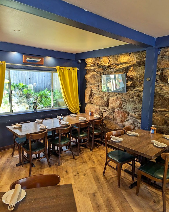 Stone walls and turquoise accents create a dining room that feels like a secret coastal hideaway you'll want to tell everyone about.