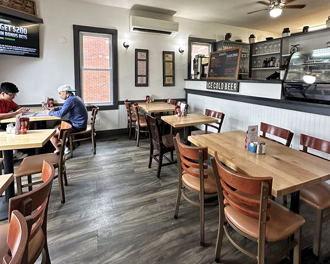 The dining area whispers "stay awhile" with its simple wooden tables, warm lighting, and the promise of ice-cold beer just steps away. 