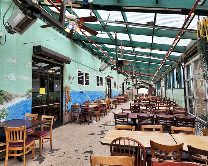 The covered patio area offers a breezy, casual vibe with coastal murals. Even the fishing nets hanging above seem to say, "Relax, you've arrived."