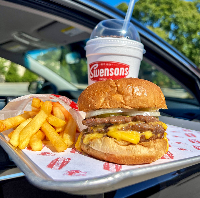The perfect burger-fries-shake trinity, arranged on a tray that hooks to your window like it was always meant to be there.
