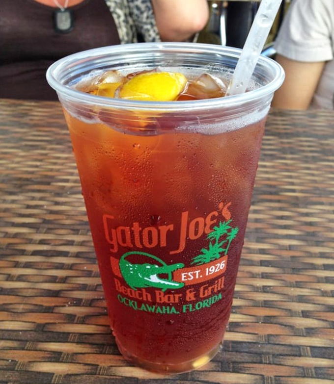 Sweet tea in a Gator Joe's cup—where Southern hospitality meets hydration in a plastic vessel that's seen more sunsets than most poets.
