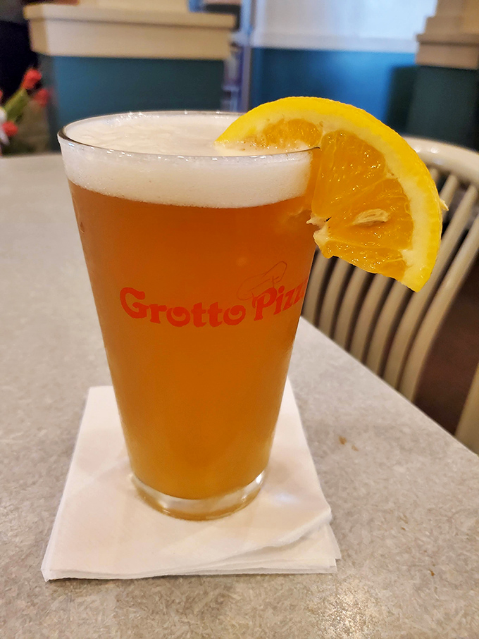 A cold beer with a citrus garnish&mdash;because sometimes the perfect pairing for great food is a moment of liquid relaxation in a Grotto-branded glass.