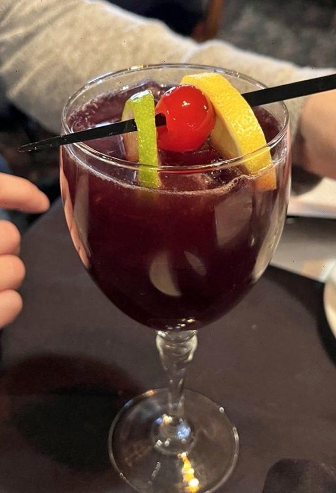 A sangria garnished like it's headed to a party, with citrus and cherry bringing both color and promise to this classic Italian restaurant libation.