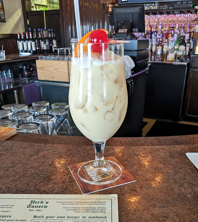 A creamy cocktail topped with a cherry that's not just a drink, but a dessert with ambition and a liquor license.