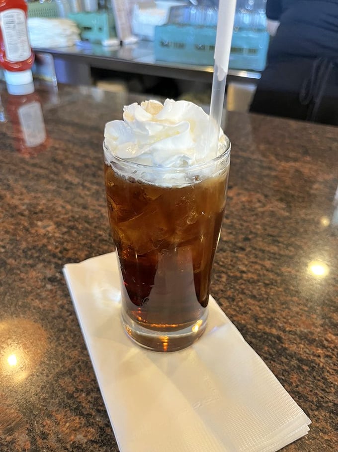 A proper diner iced tea topped with whipped cream—because sometimes your beverage deserves to wear a fancy hat too.